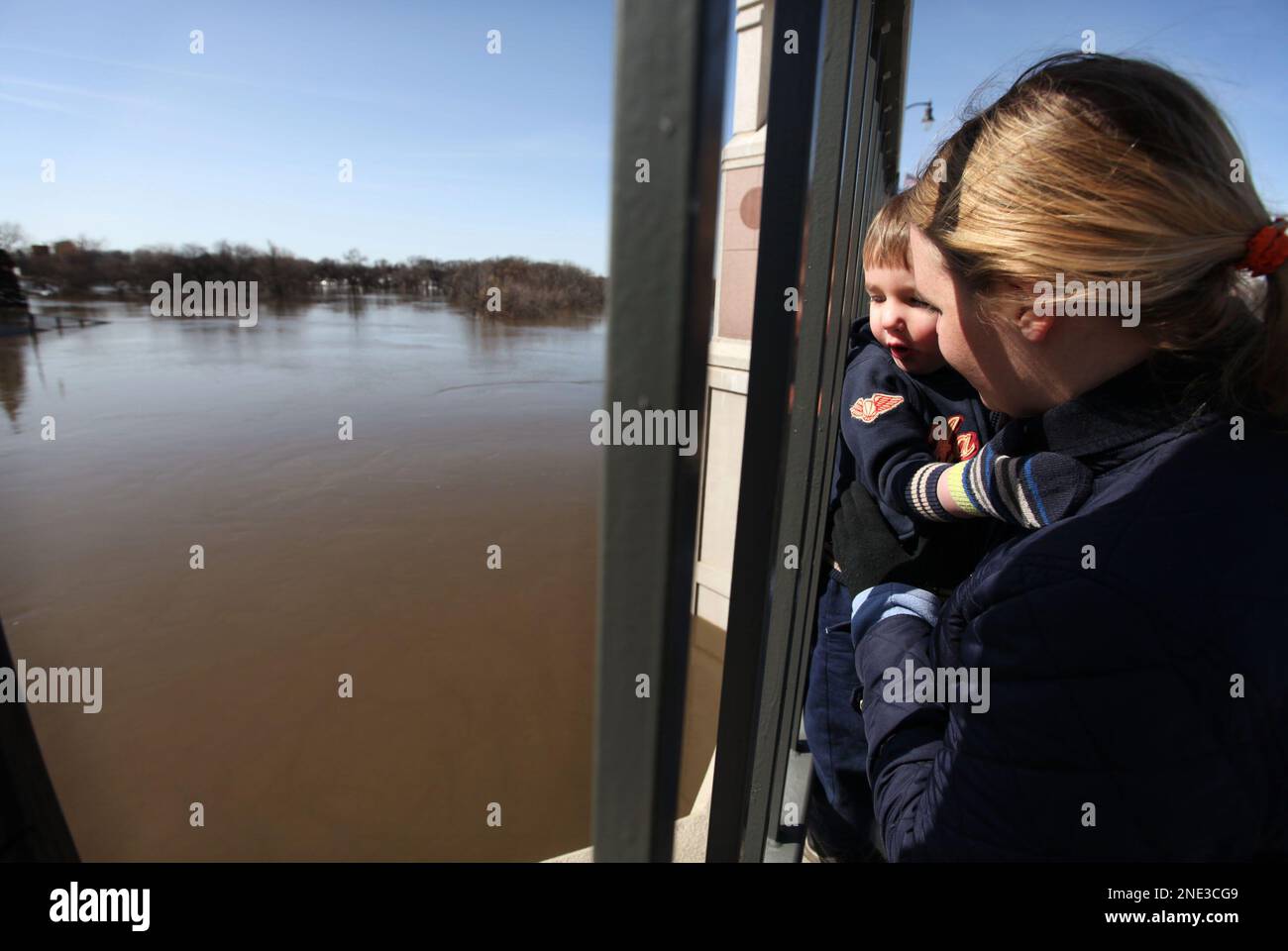 Evan Nichols, 2, hangs on to his mom, Melanie, while they observe the ...