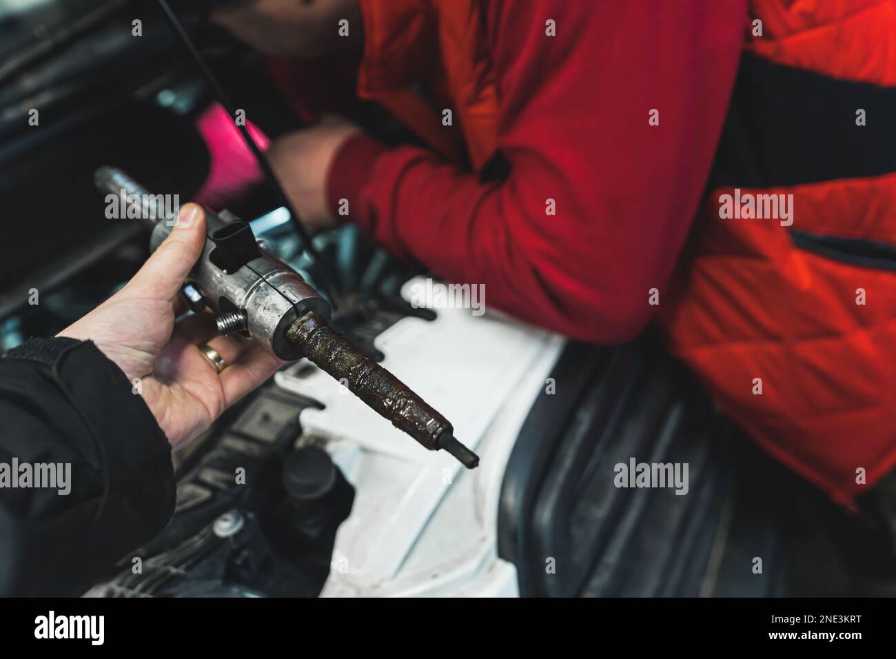 A man removing a stuck injector in diesel engine using press. High ...