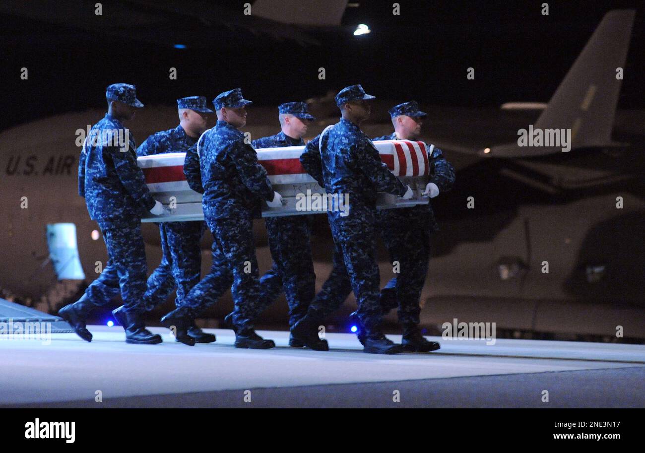 A Navy carry team carries a transfer case containing the remains of ...