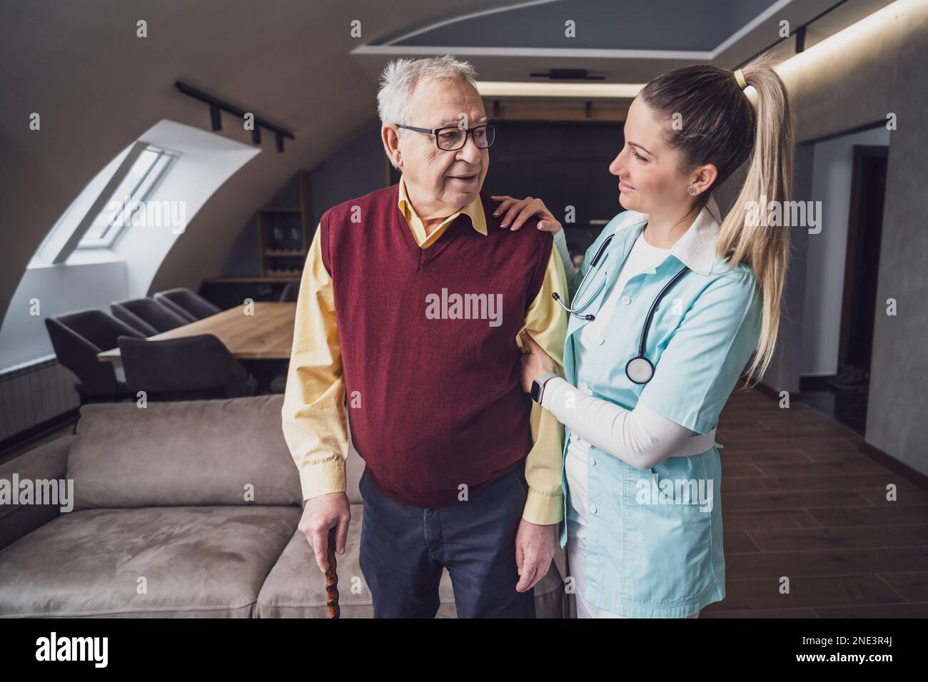 Nurse home caregiver is assisting old man at his home. Professional ...