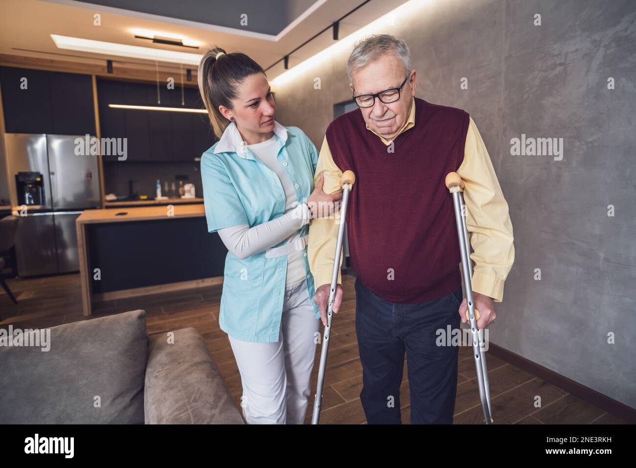 Nurse home caregiver is assisting old man at his home. Professional ...