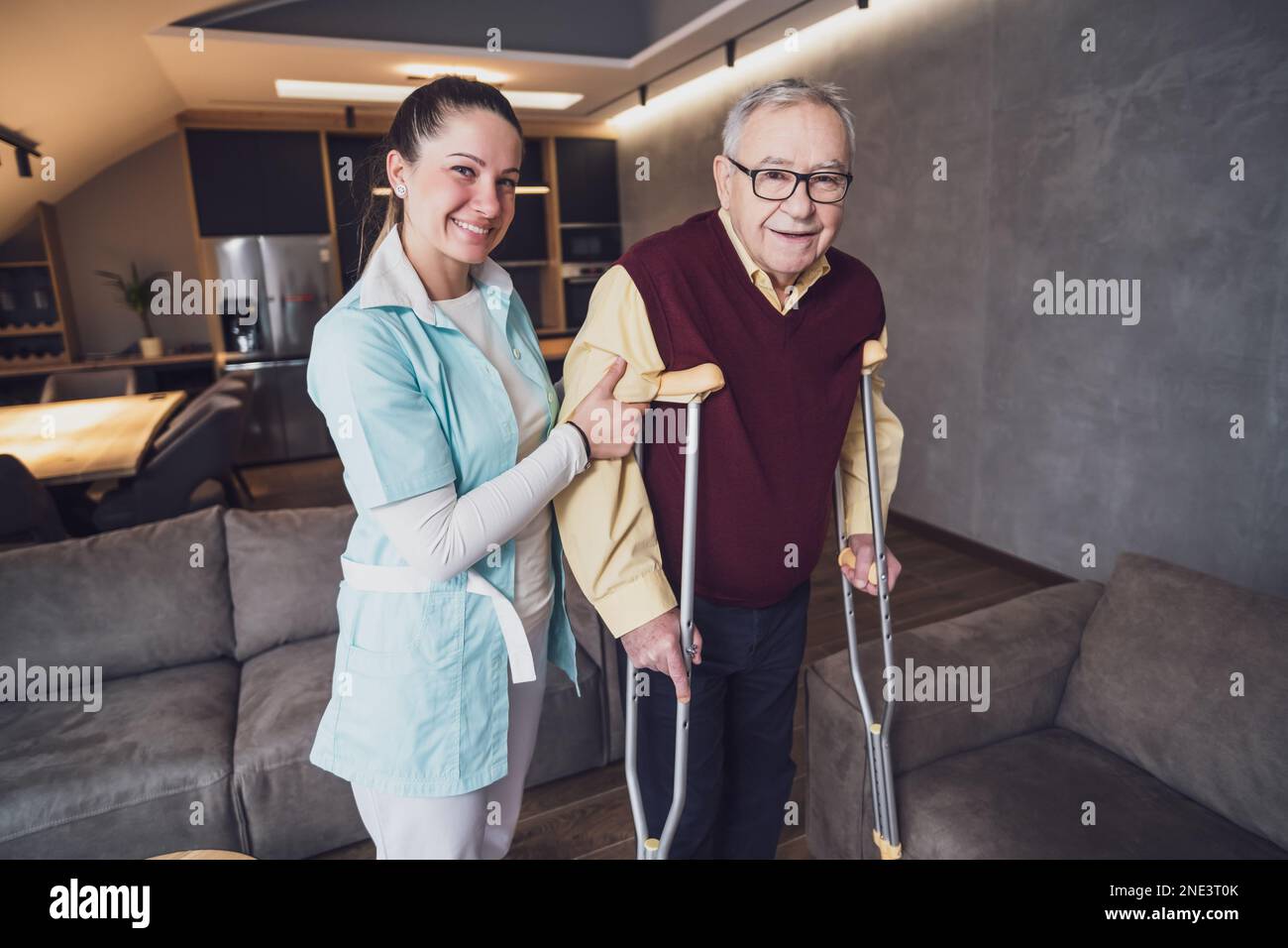 Nurse home caregiver is assisting old man at his home. Professional ...