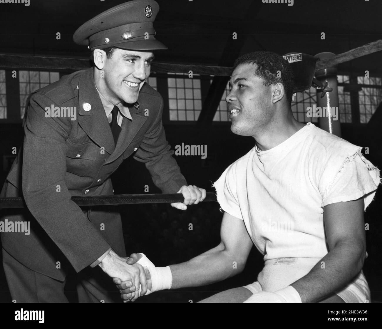 Private Billy Conn reaches into the ring to grasp the hand pf private ...