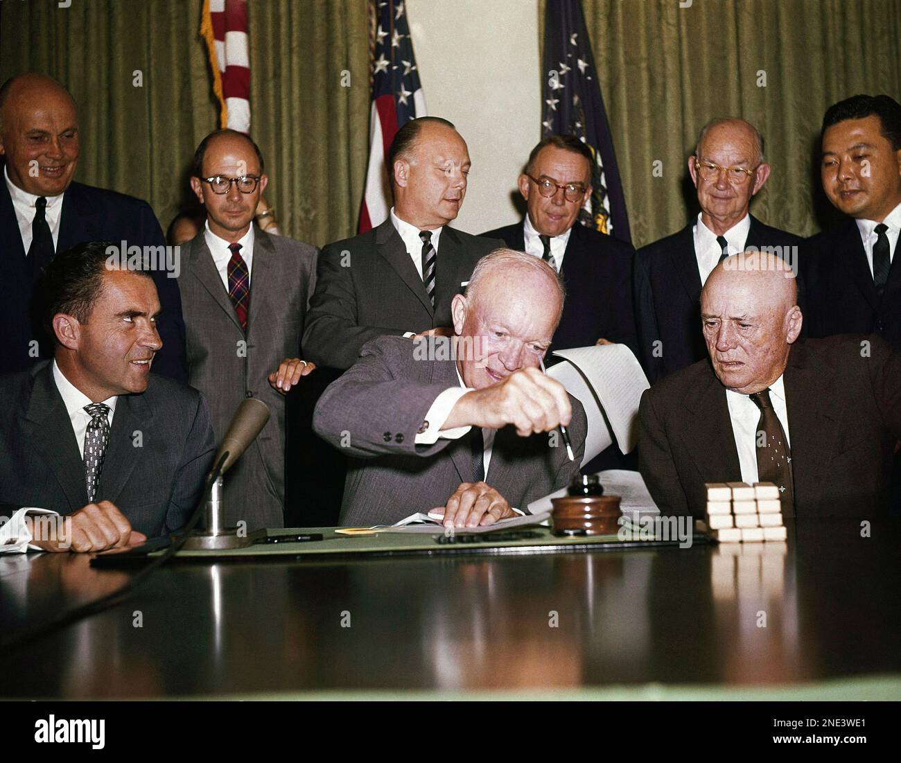 President Dwight D. Eisenhower, holding flag and signing proclamation ...