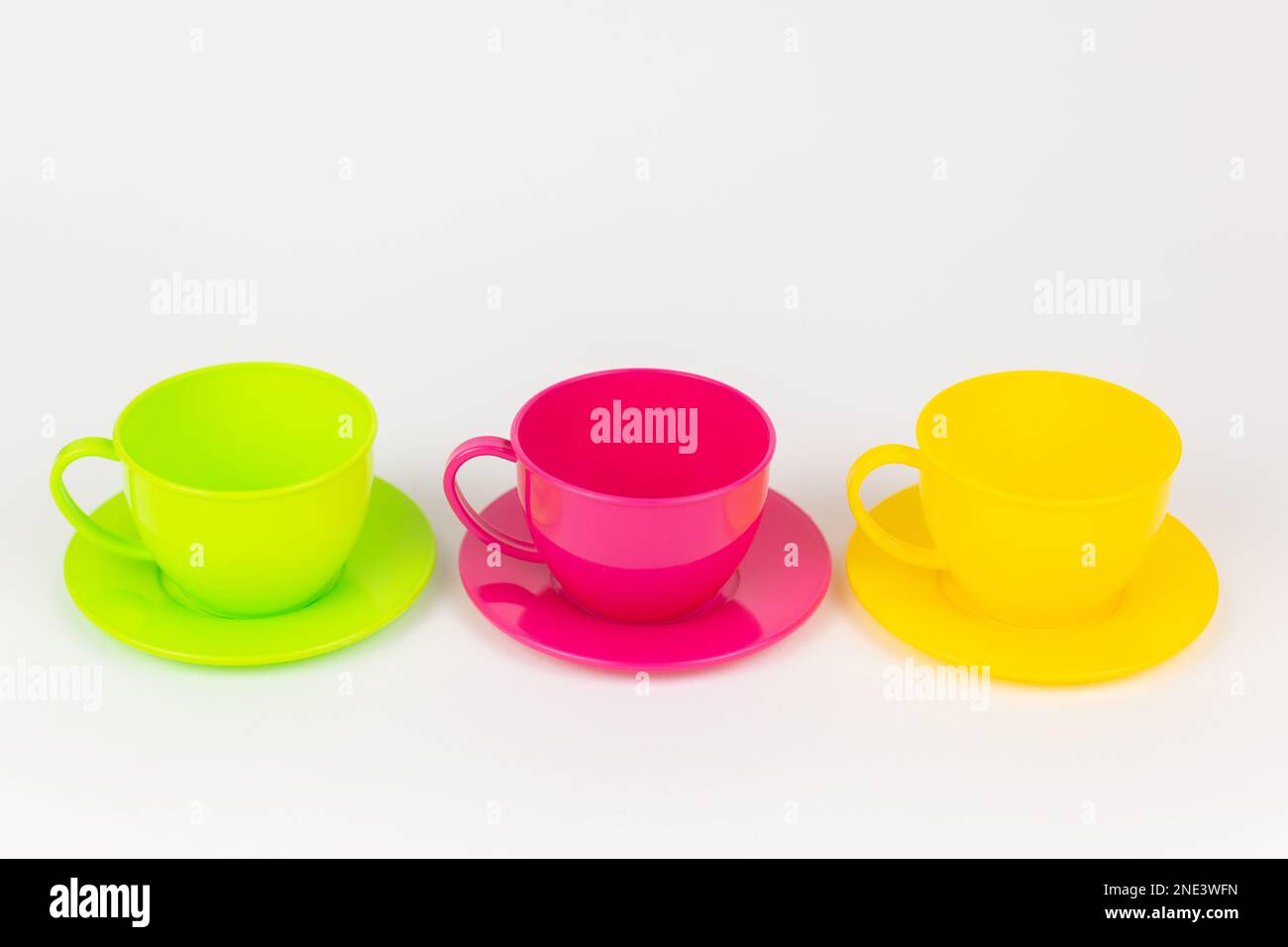 a multi-colored plastic cups and plates on a white background kitchen ...