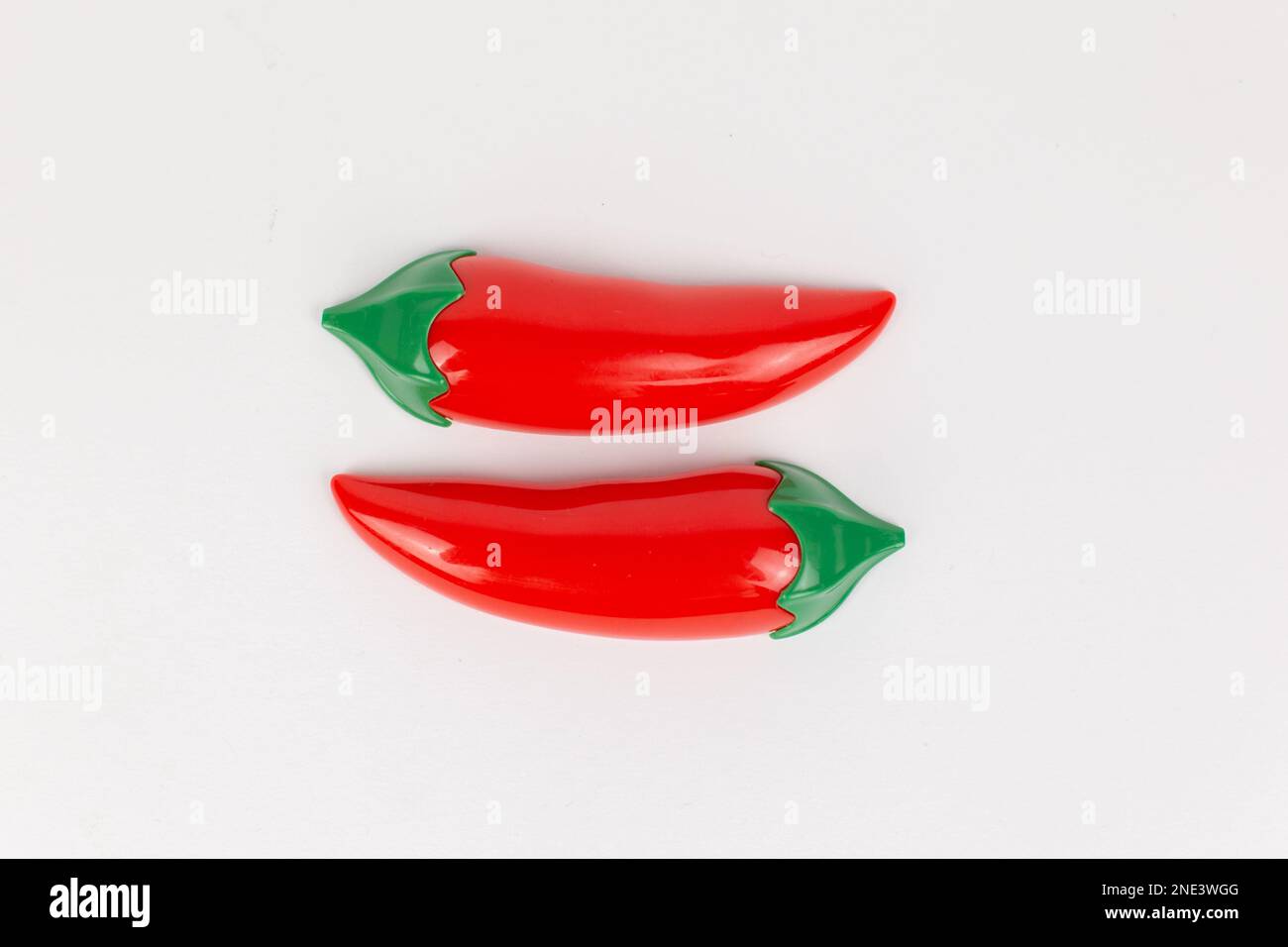 a plastic toy chili pepper on a white background Stock Photo - Alamy