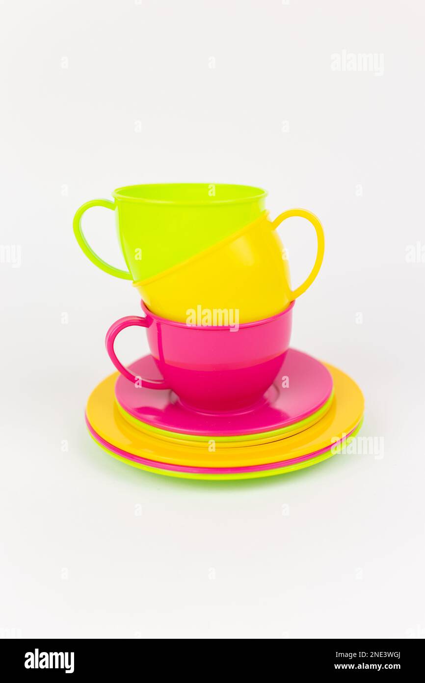 a multi-colored plastic cups and plates on a white background kitchen ...
