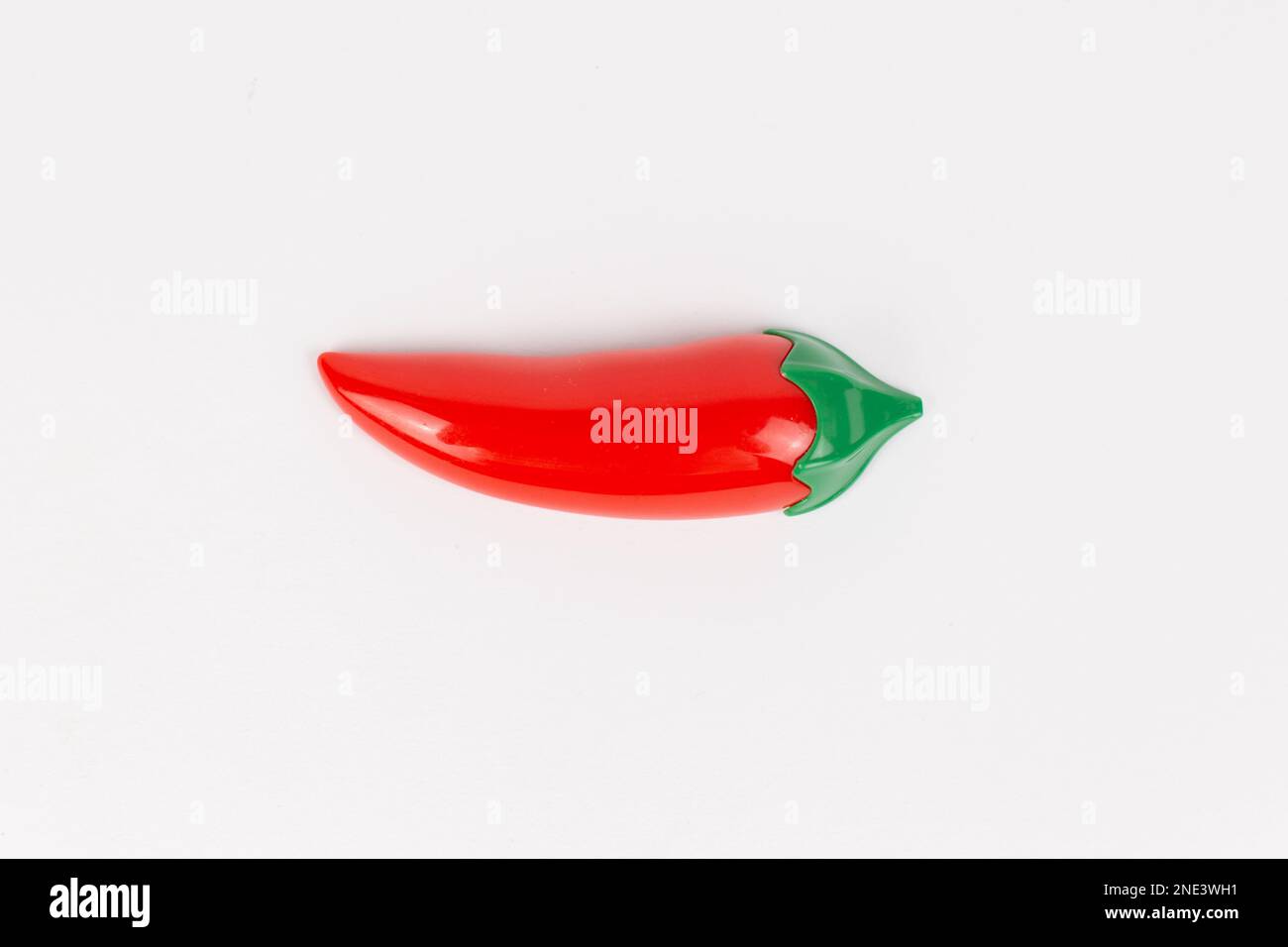 a plastic toy chili pepper on a white background Stock Photo - Alamy