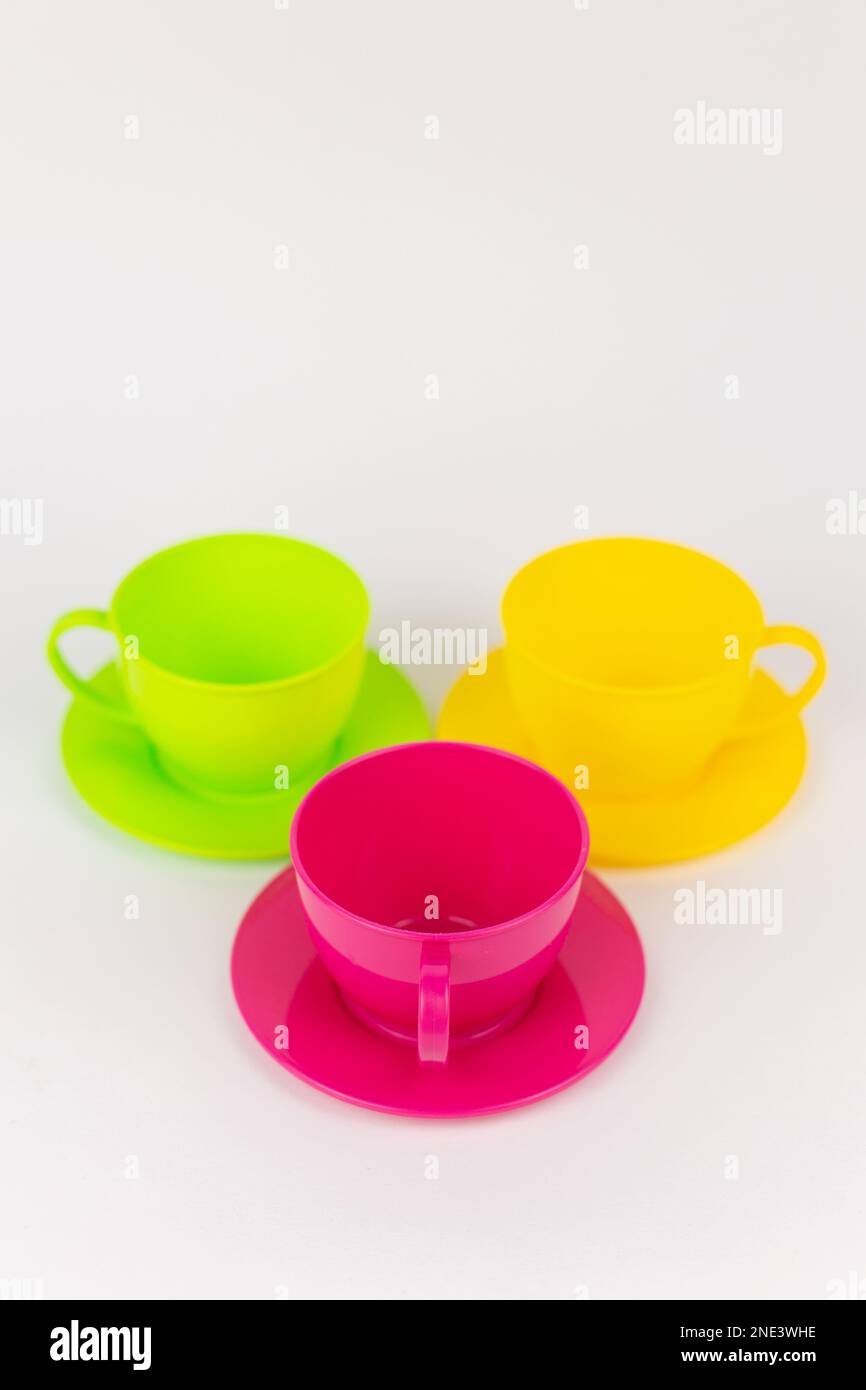 a multi-colored plastic cups and plates on a white background kitchen ...