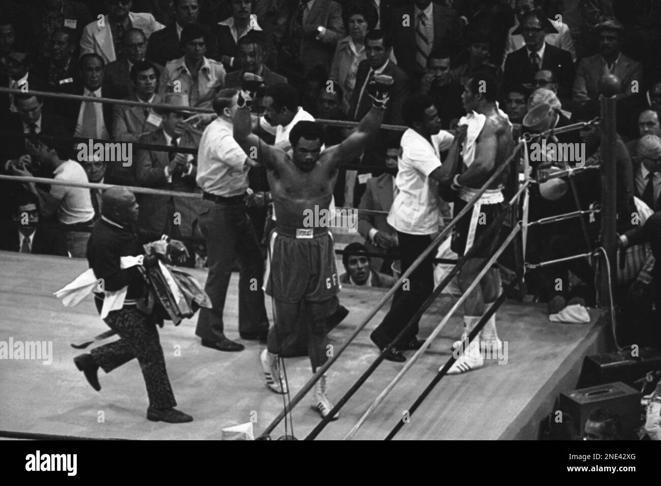 Champion George Foreman walks around ring with arms upraised as ...