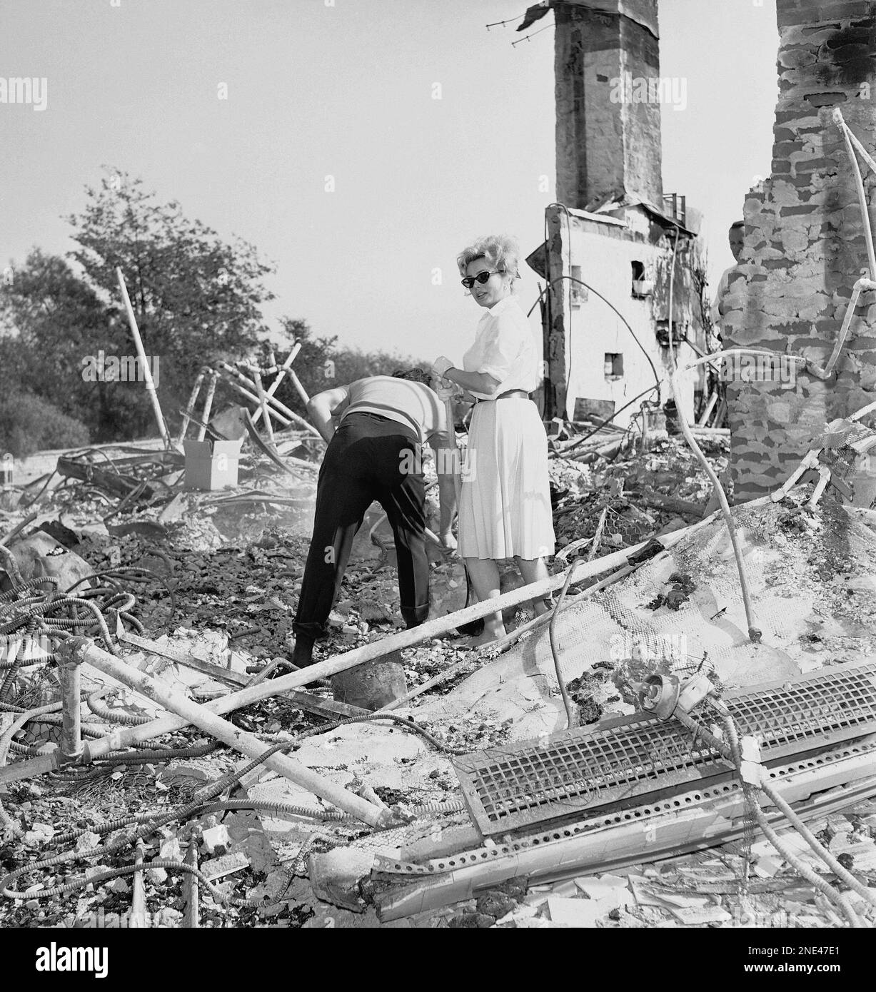 Zsa Zsa Gabor, aided by a friend, Robert Straile, digs through the ...