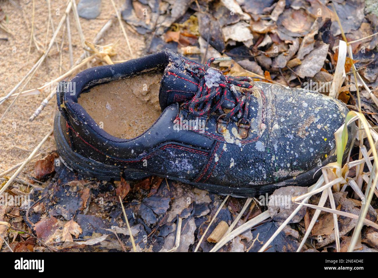a black shoe filled with sand. A shoe washed by the sea. Garbage in the ...