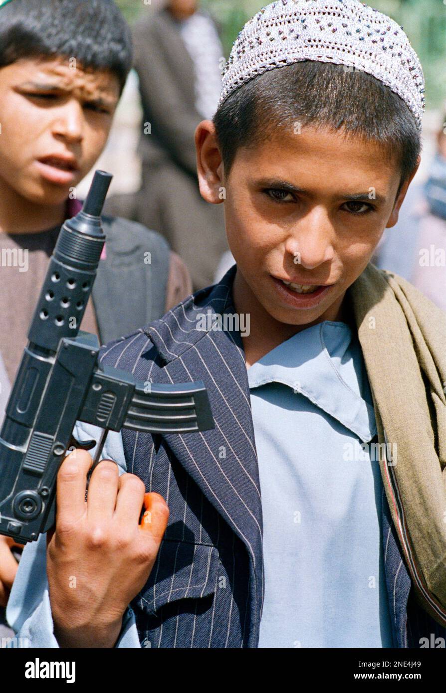 An Afghan boy poses evocatively with his toy sub-machine gun in the ...