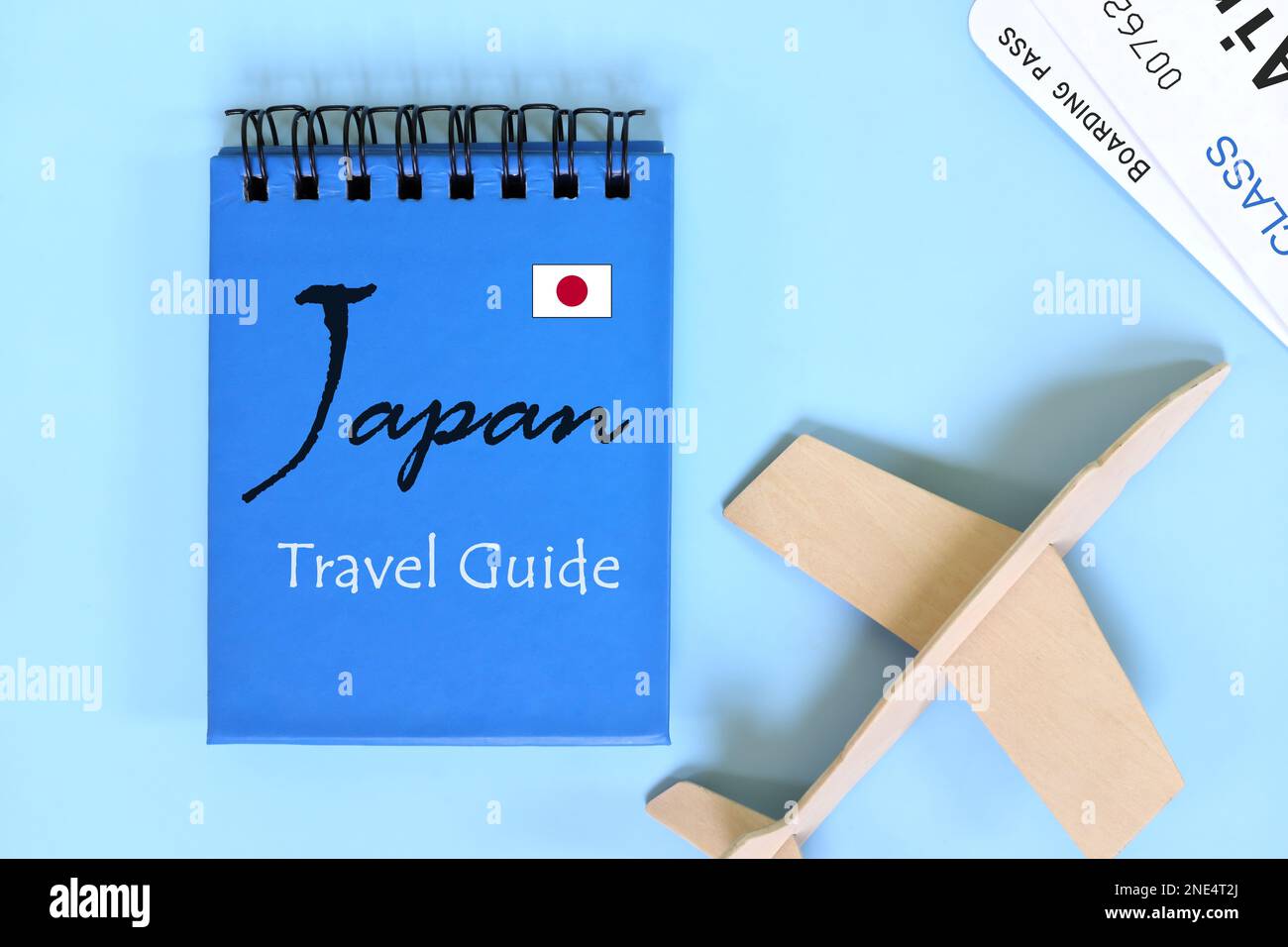 Japan travel guide written on blue notepad with flag and wooden ...