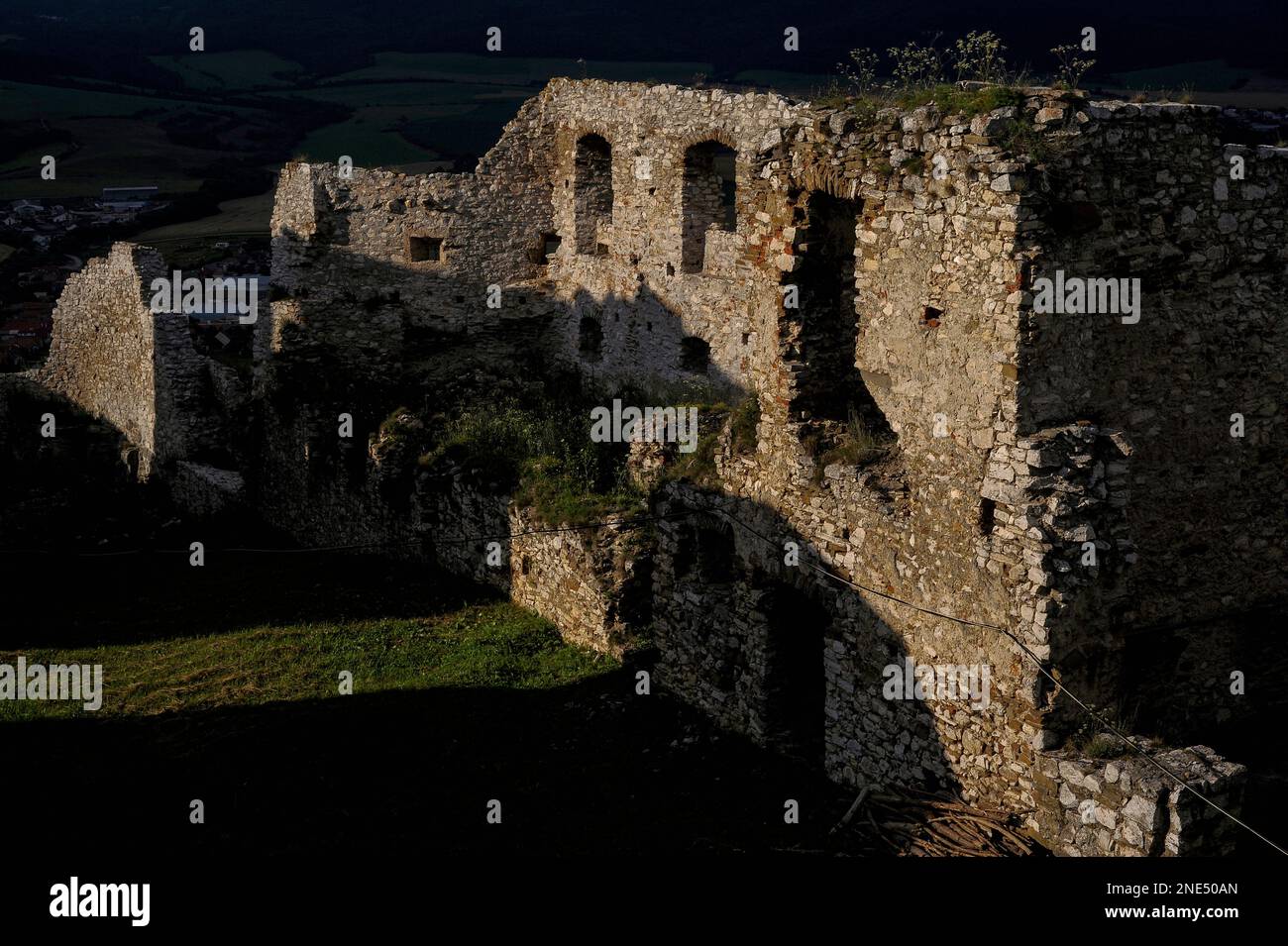 In July evening sunshine, the shadow of an ancient circular keep or ...