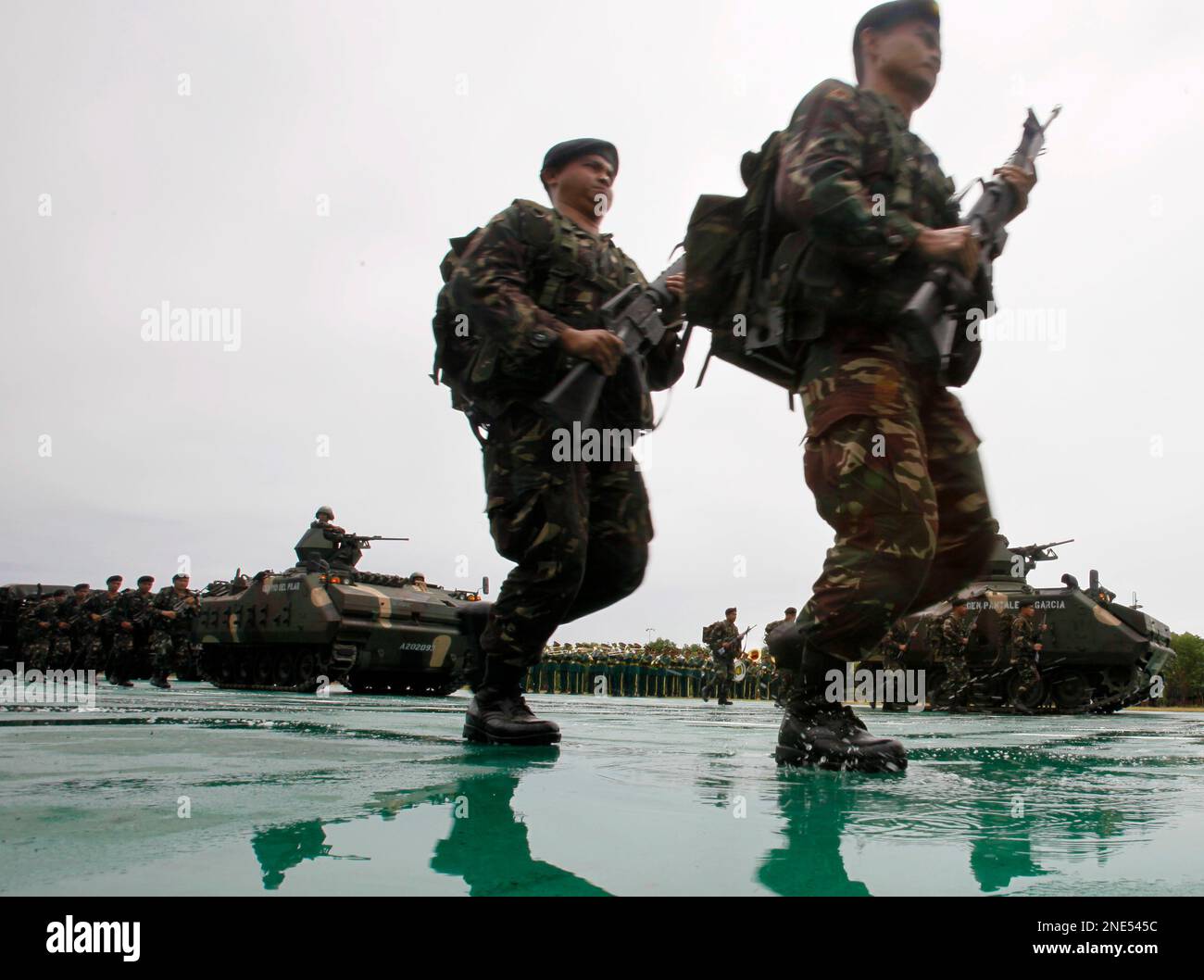 Philippine Army soldiers march with their armored personnel carriers ...