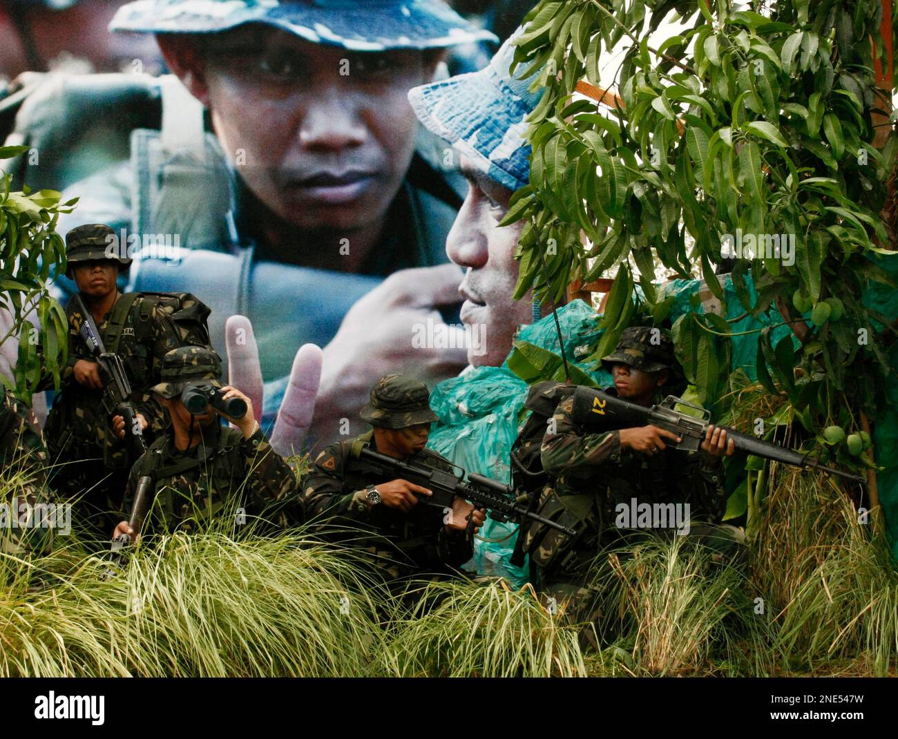 Philippine Army soldiers with guns ride a float with a tarpaulin with ...