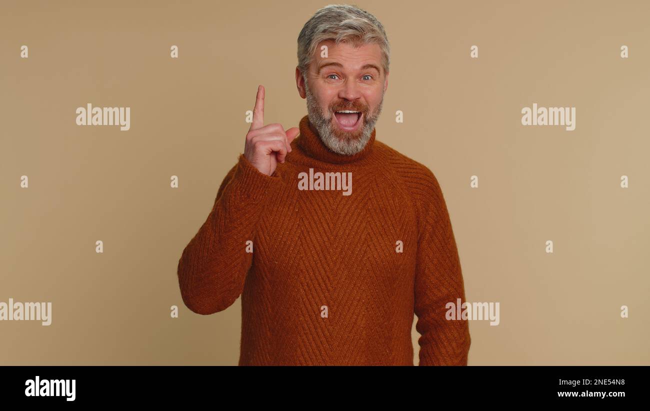 Eureka. Inspired middle-aged man pointing finger up with open mouth ...