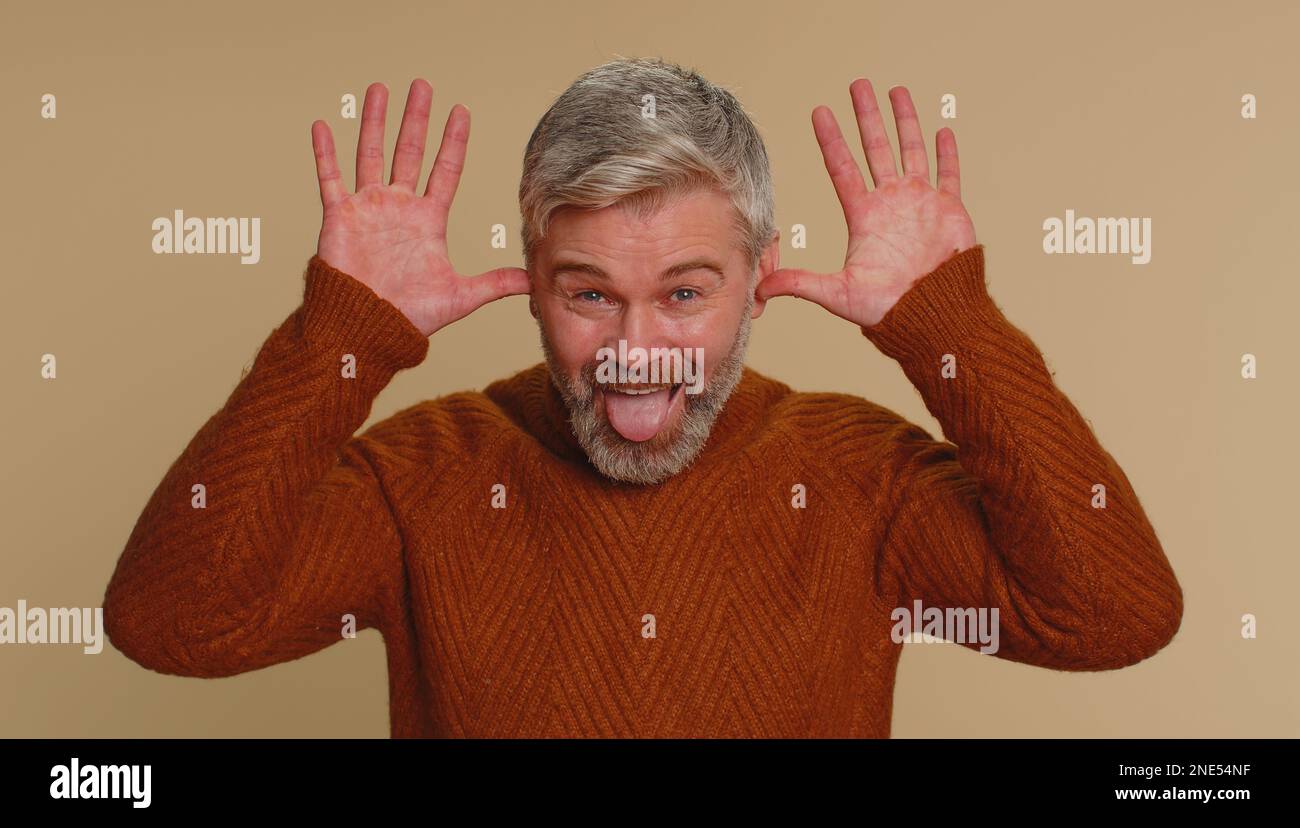 Funny joyful sincere mature man 45 years old in sweater making playful ...