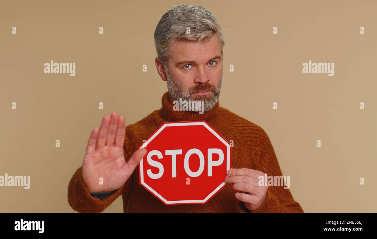 Serious middle-aged man say No, hold inscription text red No stop ...