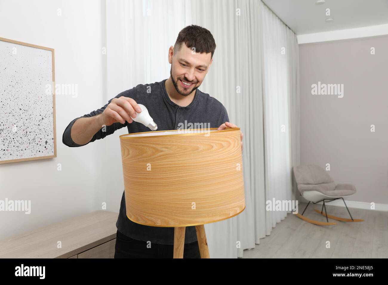 Man changing light bulb in lamp at home Stock Photo - Alamy
