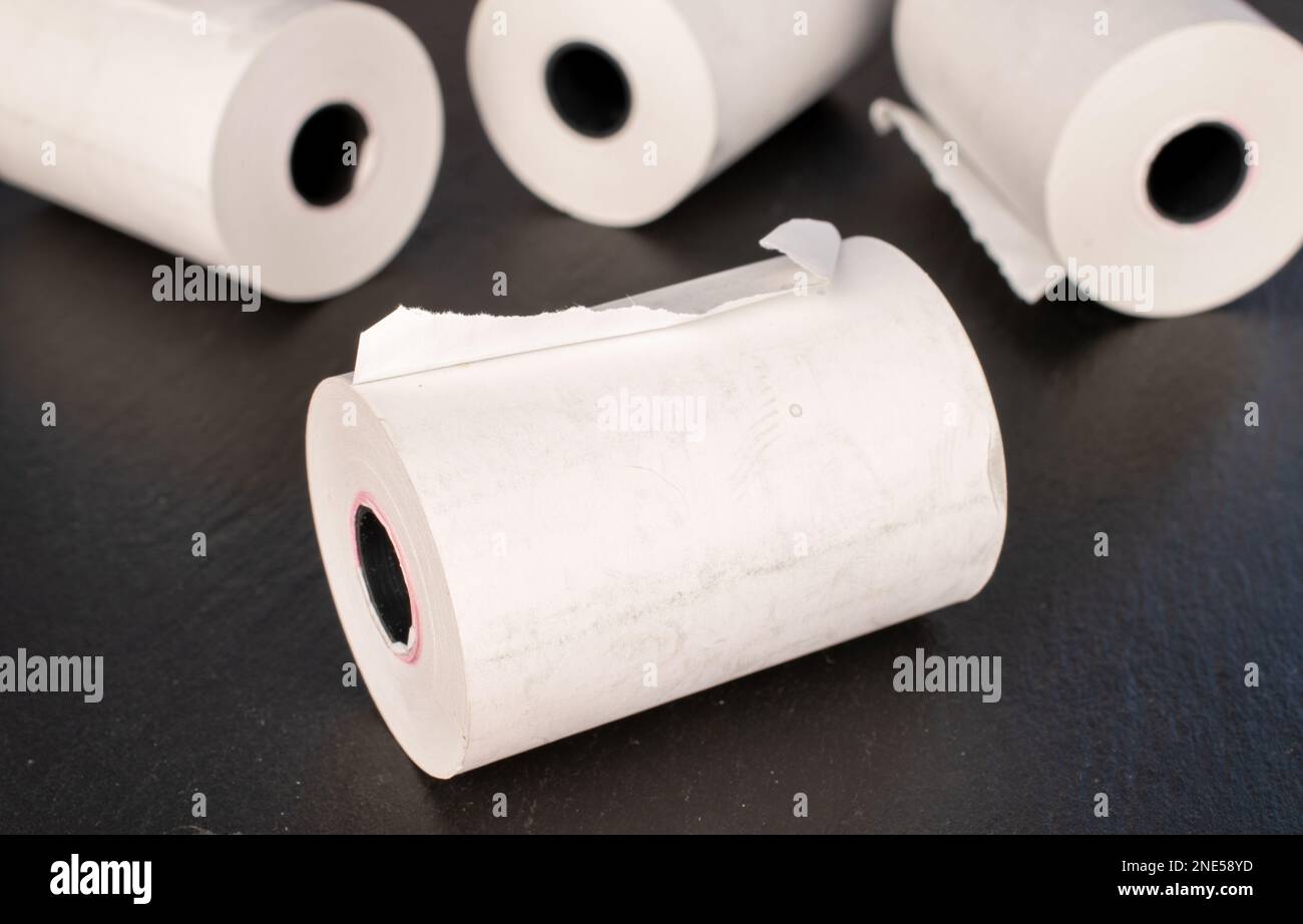 Four paper rolls of cash register tape on slate stone, close up Stock ...