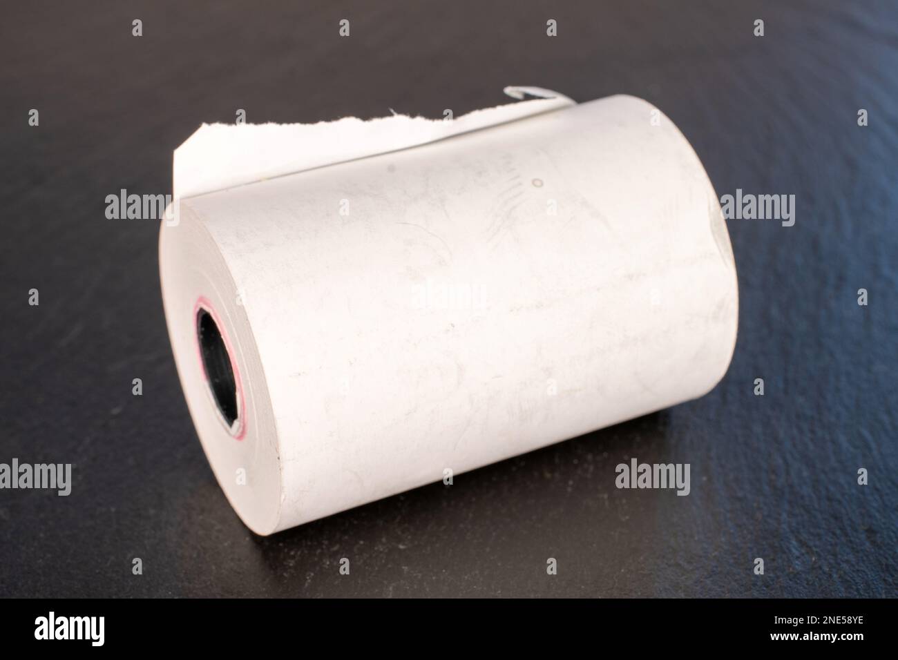 One paper roll of cash register tape on slate stone, close up Stock ...