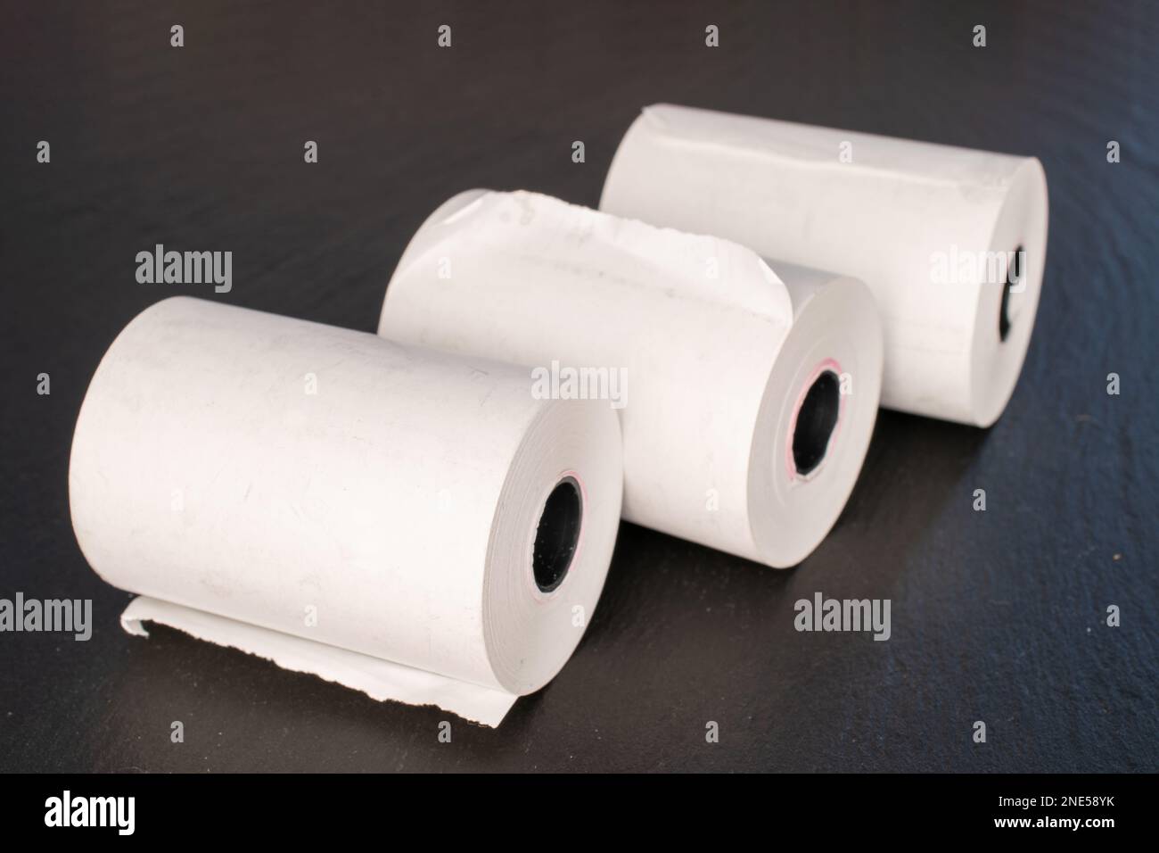 Three paper rolls of cash register tape on slate stone, close up Stock ...