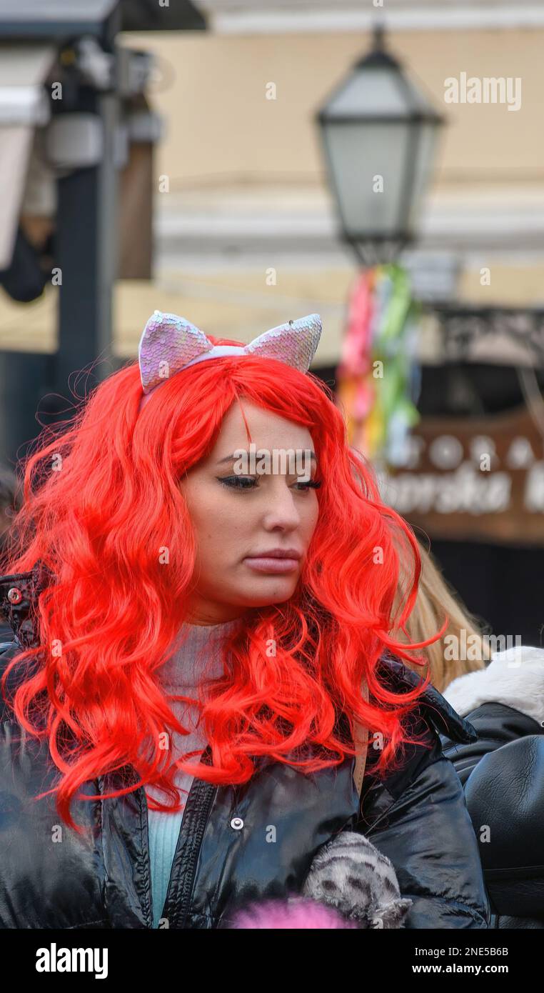 A vertical portrait of a female wearing a red wig at carnival Stock ...
