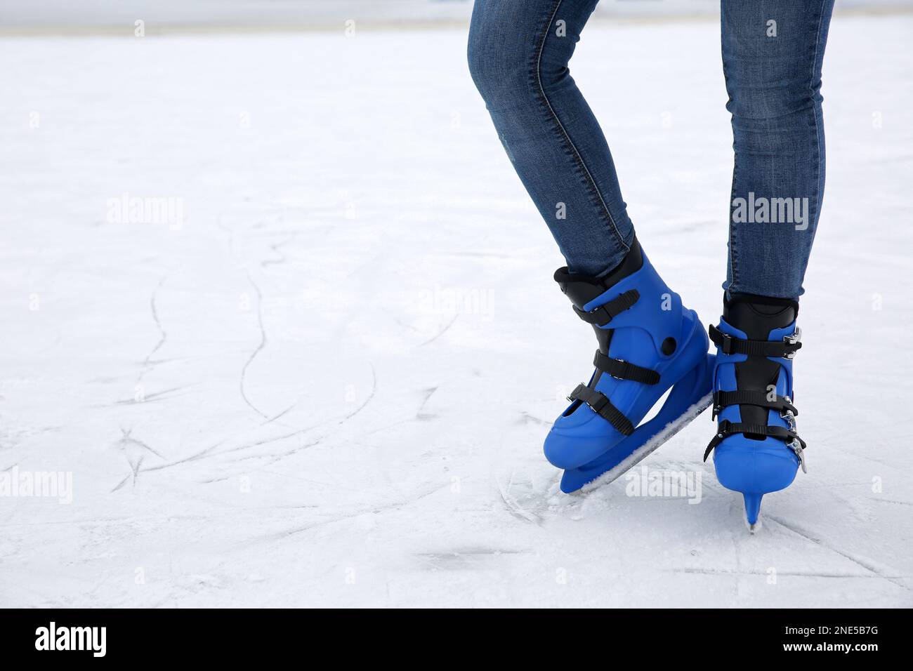 Woman wearing figure skates on ice rink, closeup. Space for text Stock ...
