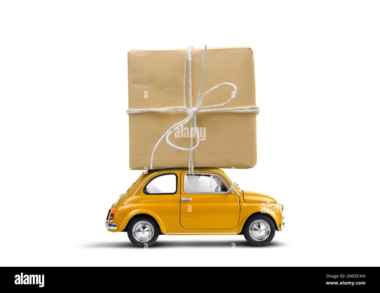 Retro yellow toy car delivering gift box atop on a white background ...