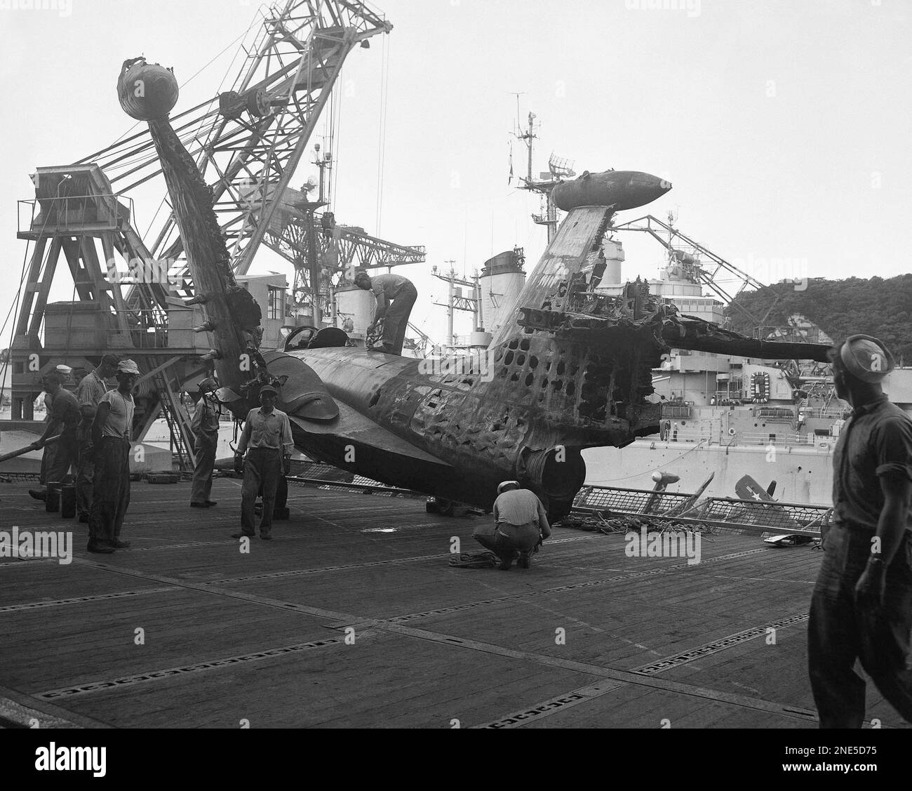 Sailors aboard the aircraft carrier Boxer prepare a damaged jet fighter ...