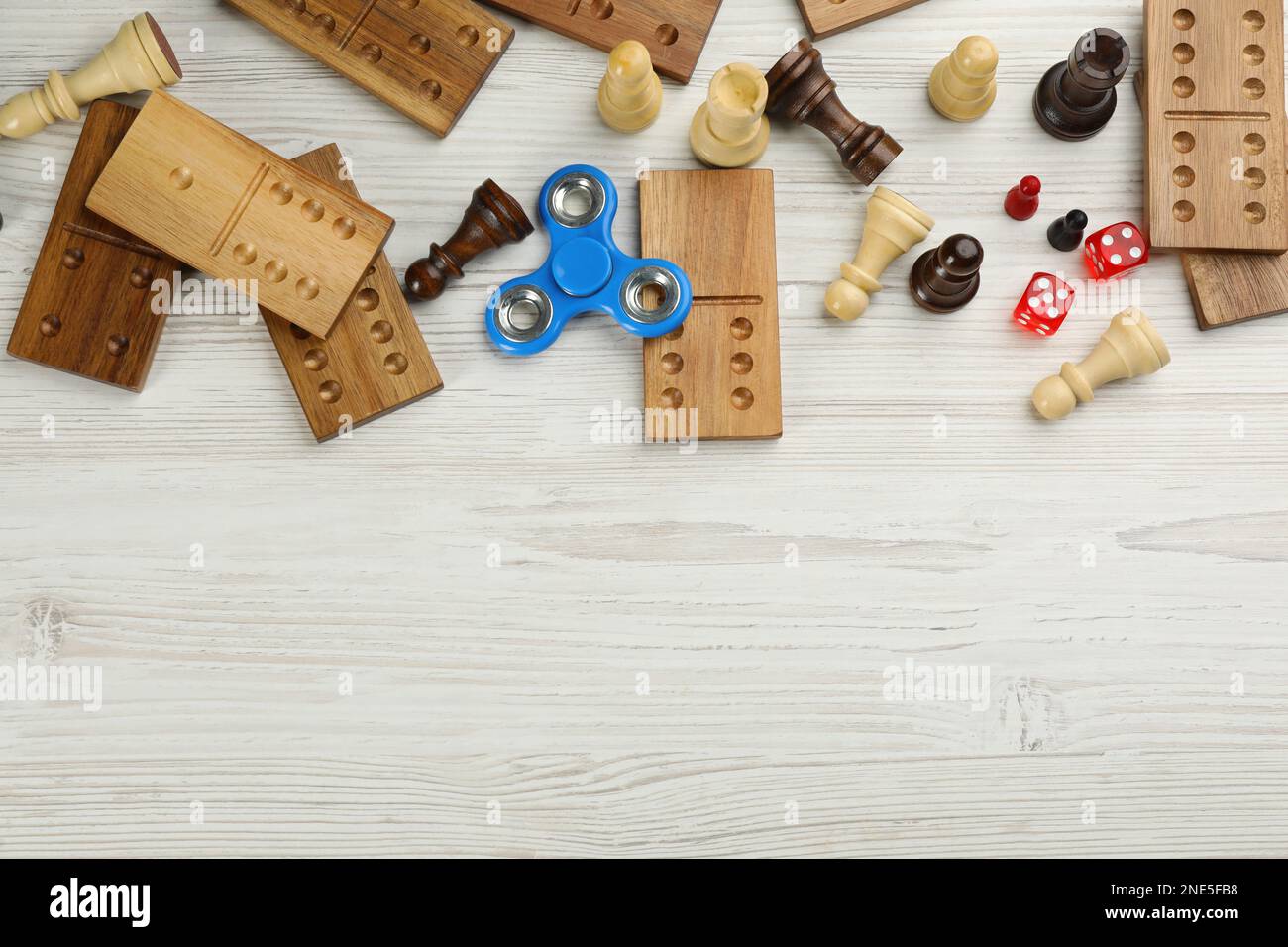 Elements of different board games on white wooden table, flat lay ...