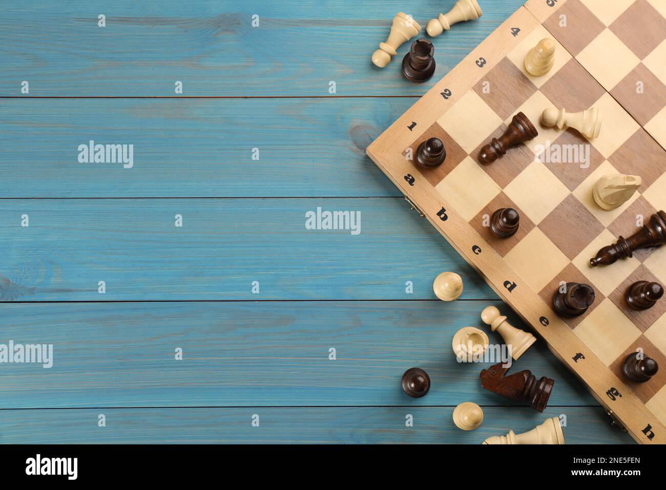 Flat lay composition of chess on light blue wooden table, space for ...