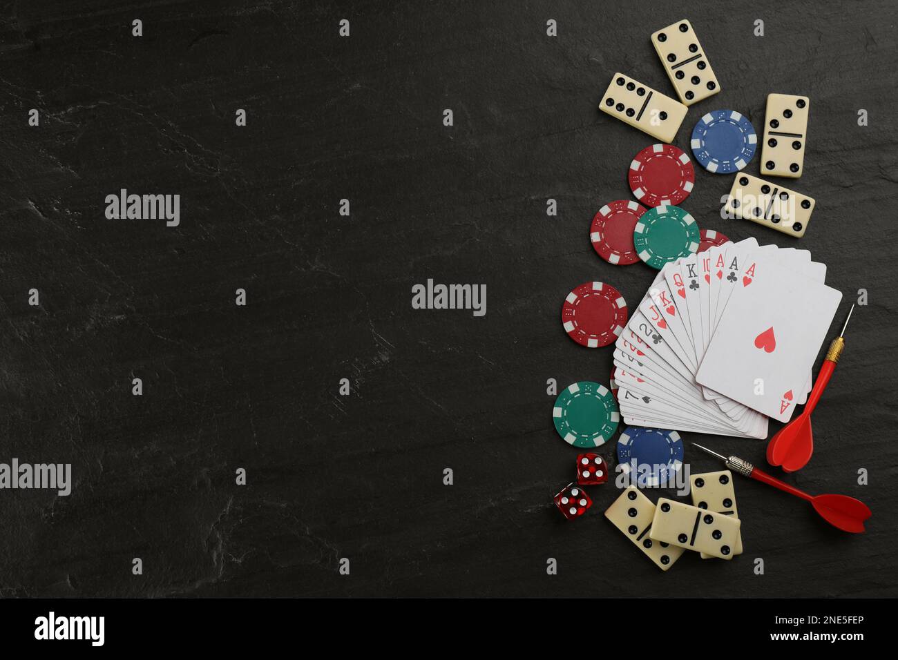 Elements of different board games on black slate table, flat lay. Space ...