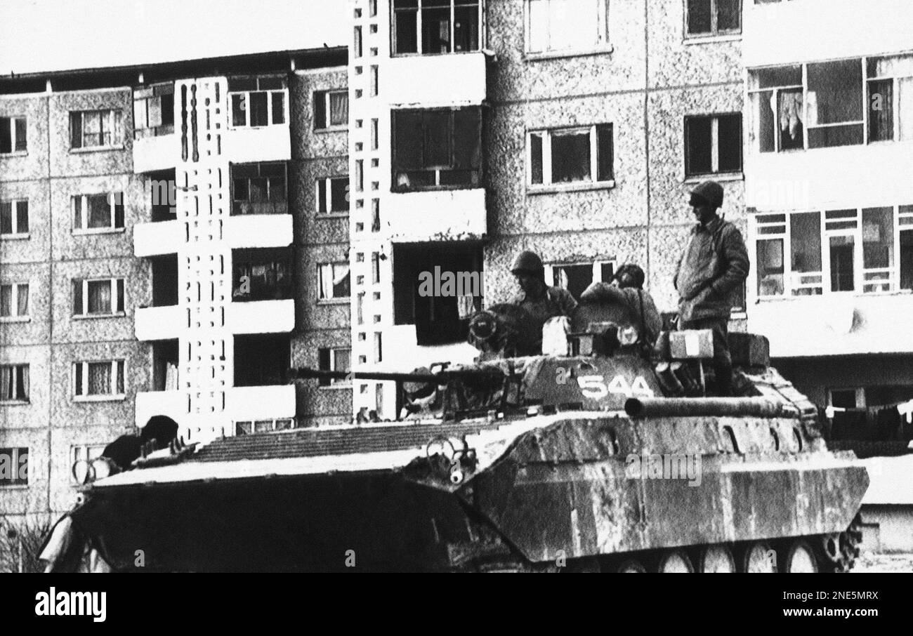 The crew of a Soviet armoured personnel carrier sits on their vehicles ...
