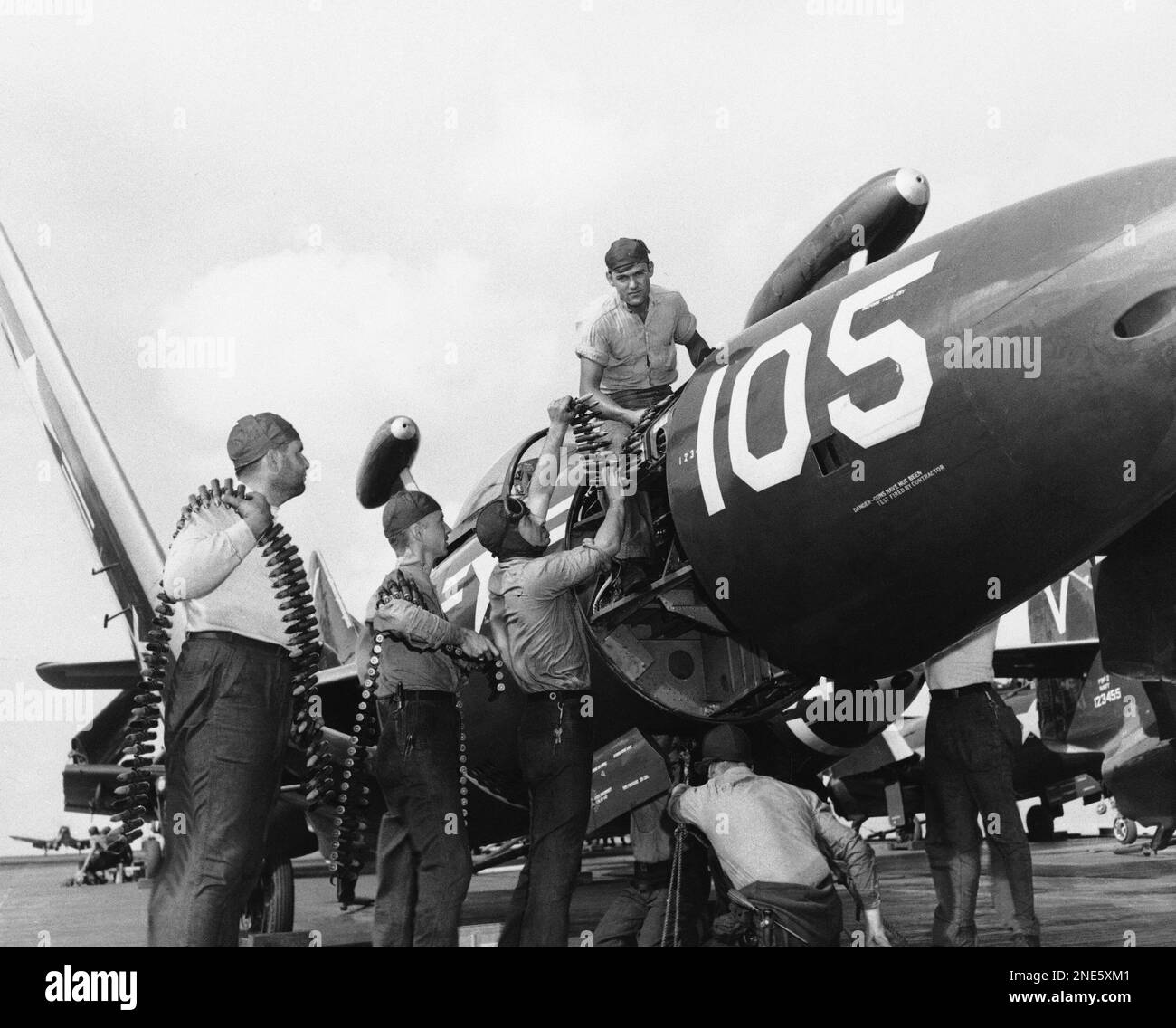 Navy ordnanceman of a Task Force 77 aircraft carrier load belts of 20 ...