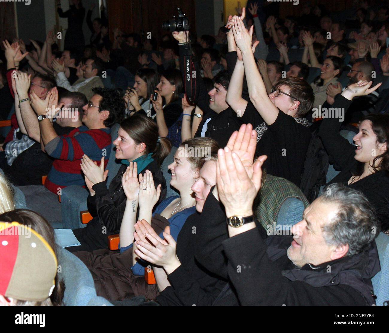 Visitors cheer at a movie theatre in Vienna showing a live Oscars ...