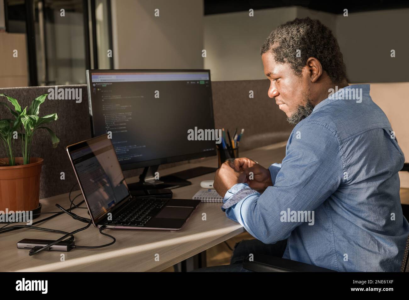 Black Man Writing Lines of Code On Desktop PC With Two Monitors and a ...