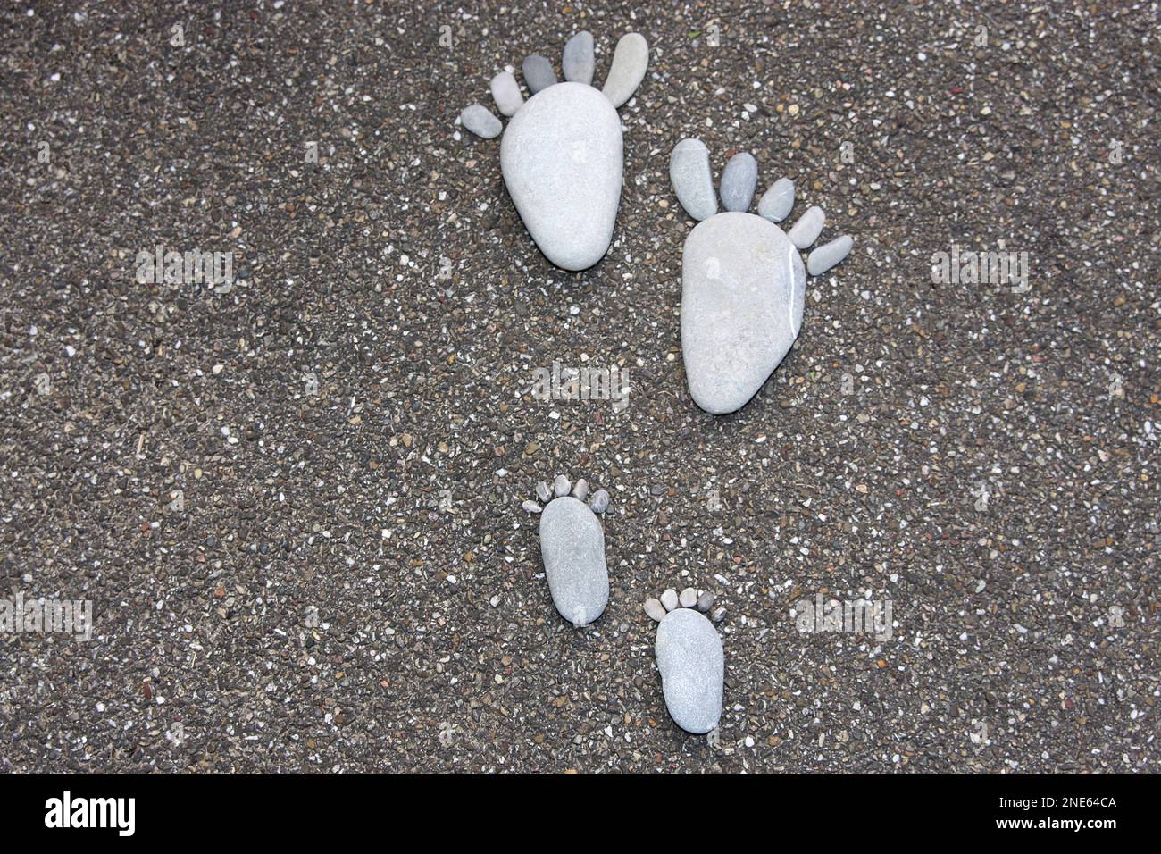 large and small stone feet on asphalt Stock Photo - Alamy