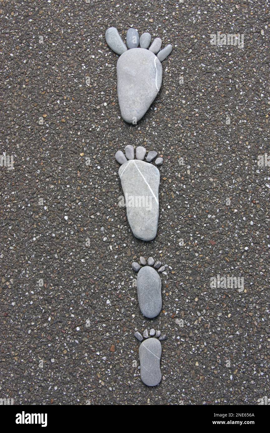 large and small stone feet on asphalt Stock Photo - Alamy