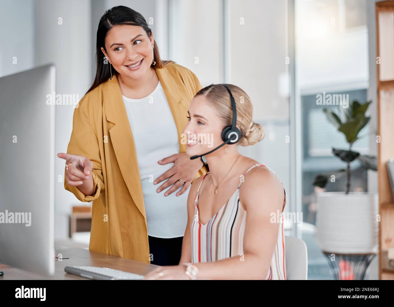 Call center, coaching and pointing at computer in office with pregnant ...