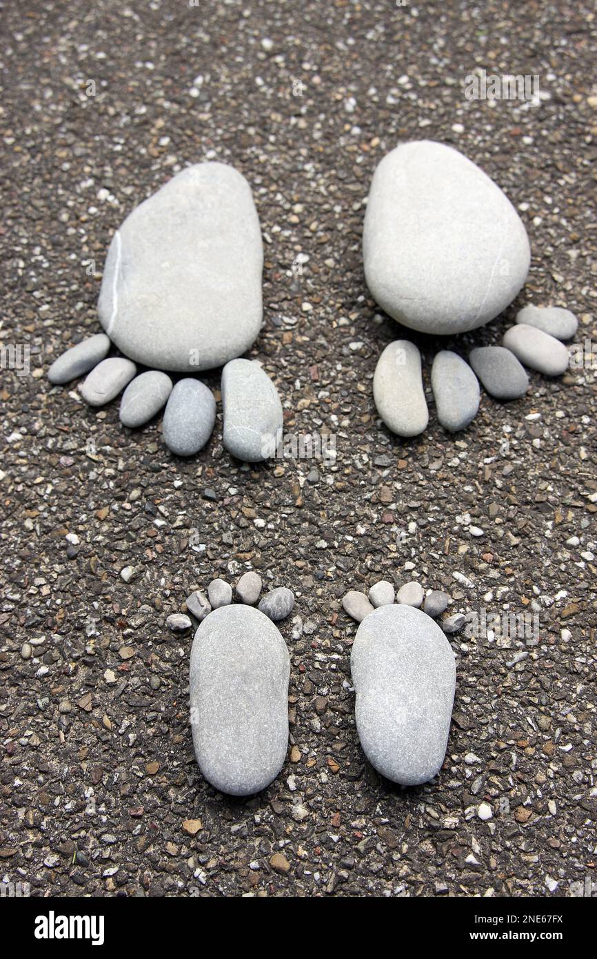 large and small stone feet on asphalt Stock Photo - Alamy