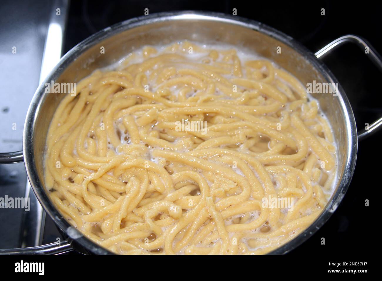 cooking fresh egg spaetzle in a pot Stock Photo - Alamy