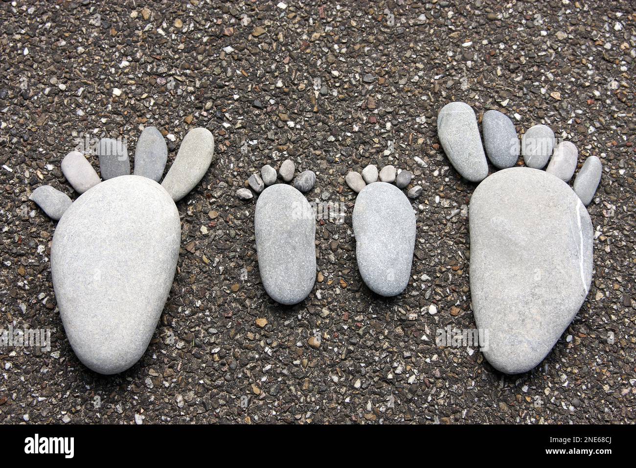 large and small stone feet on asphalt Stock Photo - Alamy