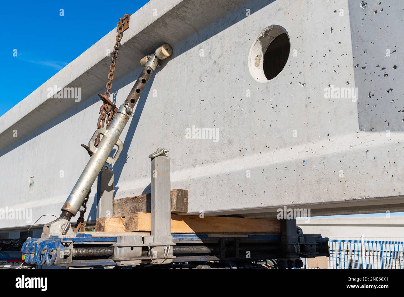 A large concrete beam secured by a hydraulic mechanism and chains to a ...