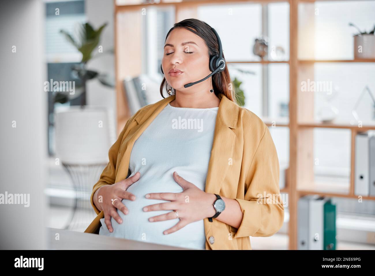 Office, stress and pregnancy, breathing exercise and woman at desk with hand on stomach in call ...