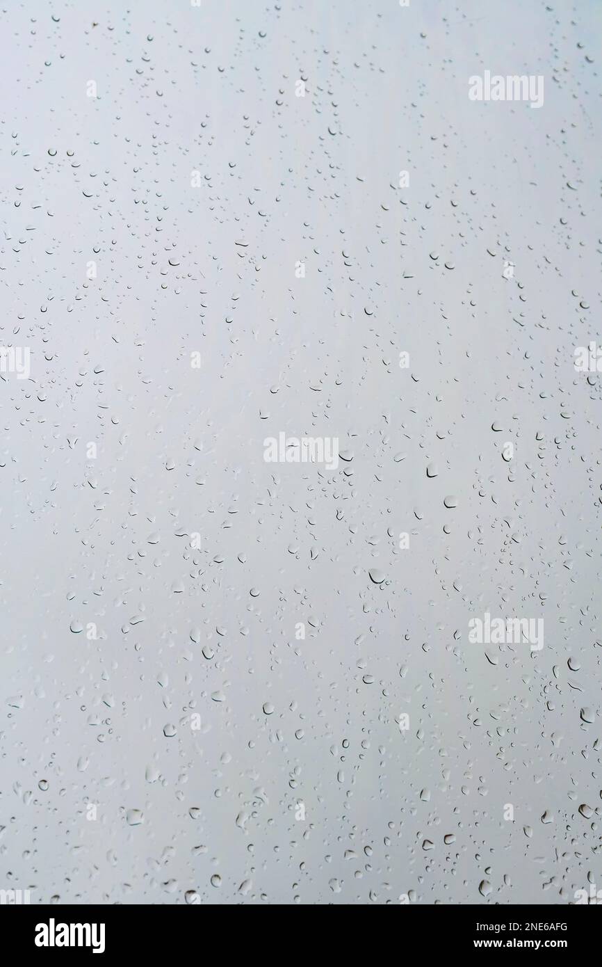 Texture surface from drops of autumn cold rain on window glass against blurred background of ...