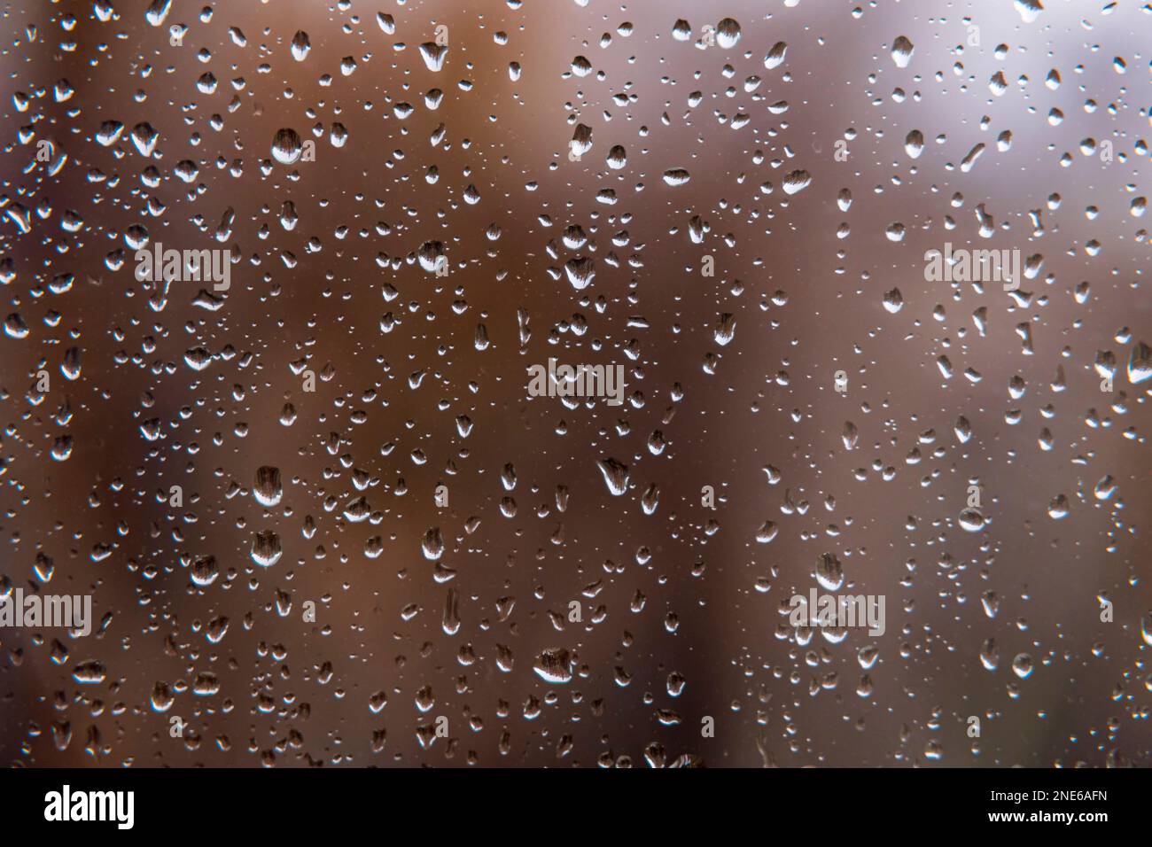 Textured surface of drops of autumn cold rain on window glass against ...