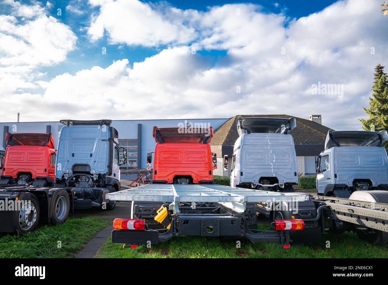 Rear view of white and red tractor semi-trailers. Blue sky with ...